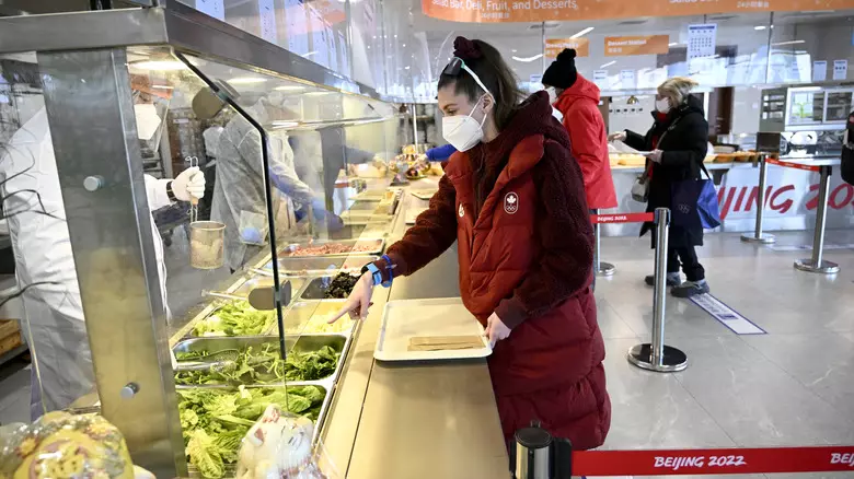 Urheilijat jonottavat ruokaa Pekingin olympiakylässä