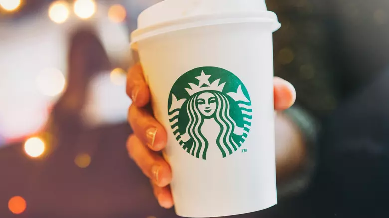 Starbucks чөйчөгүн сунуп жаткан кол