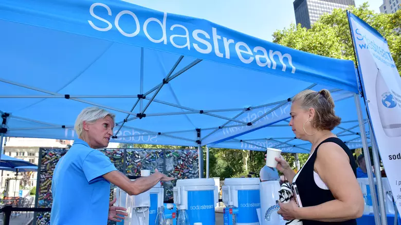 du homoj ĉe subĉiela SodaStream-tendo