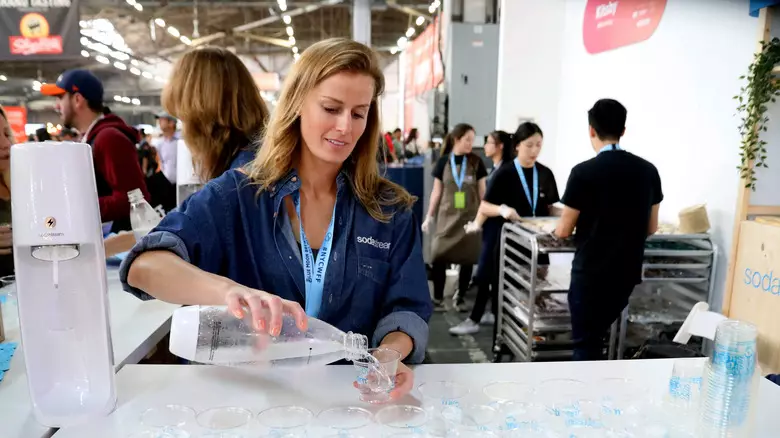 mujer vertiendo agua SodaStream en una taza