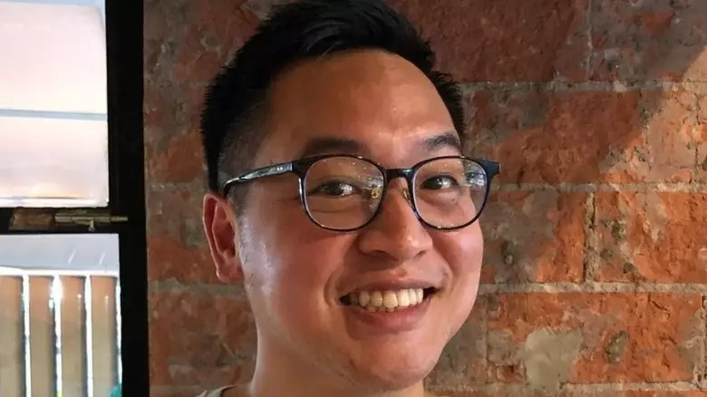 Justin Yu con gli occhiali e sorridente