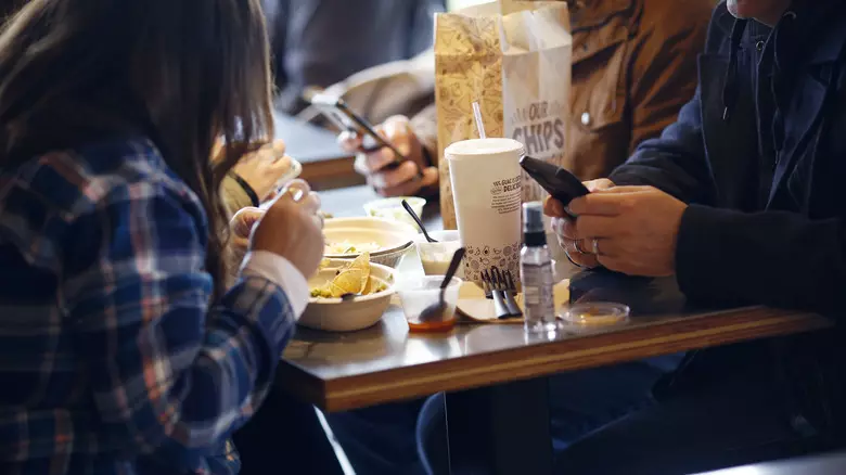 két ember ül és eszik a Chipotle-ban