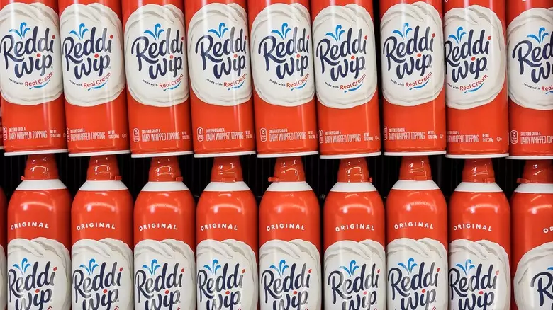 Duas fileiras de latas vermelhas Reddi-wip