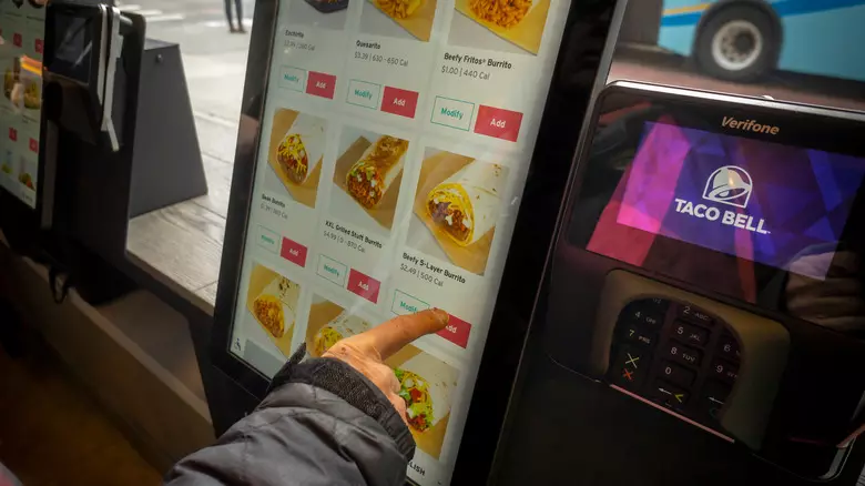 Asmuo, užsisakantis Taco Bell naudojant jutiklinį ekraną