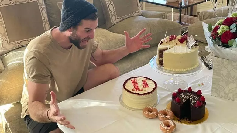 Liam Hemsworth posando con tortas de cumpleaños