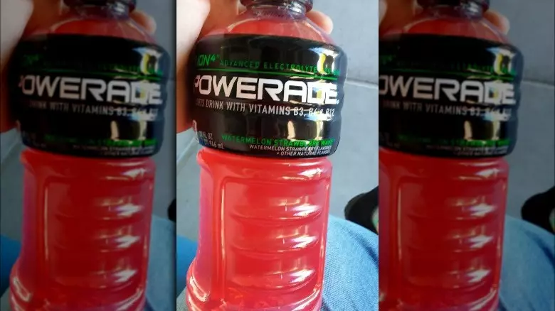 Någon håller i Powerade Watermelon Strawberry Wave-flaska