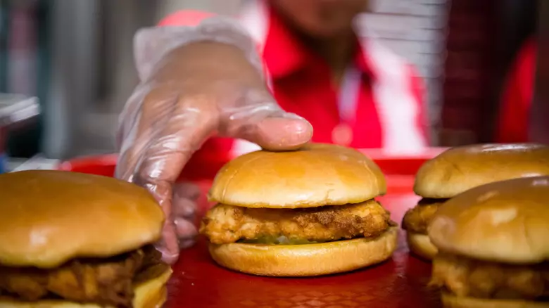 Chick-Fil-En ansatt som håndterer en kyllingsmørbrød