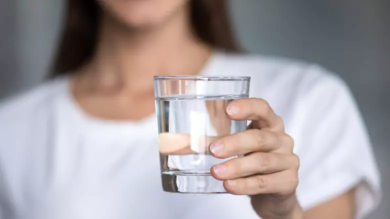 Babaye nga nagkupot ug usa ka baso nga tubig