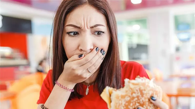 Awéwé biting kana burger jeung buuk