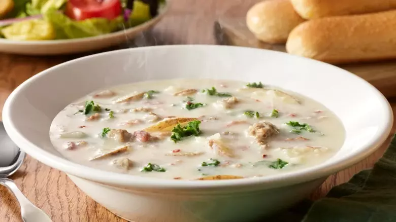 En skål Zuppa Toscana med brødstænger