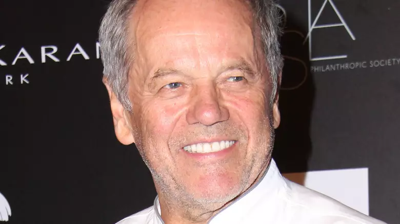 Wolfgang Puck sorrindo cunha chaqueta de chef