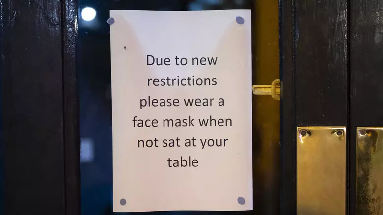 Знак који објашњава недавне мандате маски у ресторанима