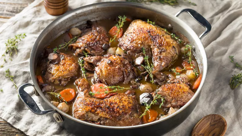 Okrogla ponev coq au vin, okrašena s timijanom