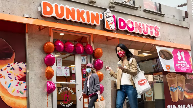 umfazi phambi kwevenkile yaseDunkin' Donuts