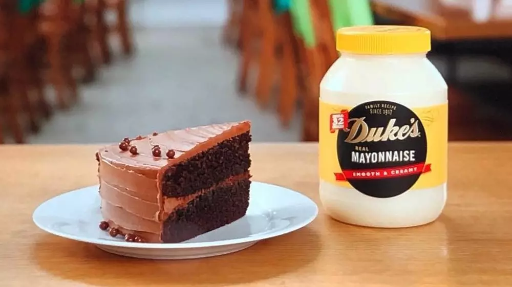 Tranche de gâteau au chocolat sur une assiette à côté d'un pot de Duke's Mayonnaise