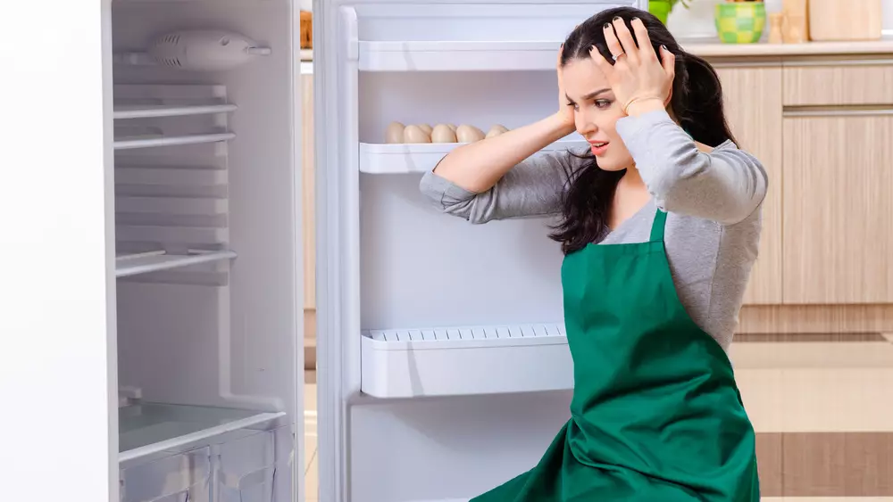 babaeng naglilinis ng kanyang refrigerator