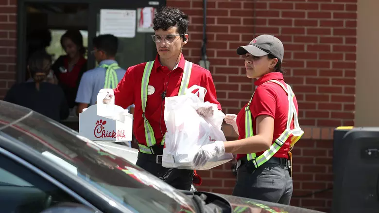 Mga empleyado ng Chick-fil-A na may hawak na pagkain sa drive thru