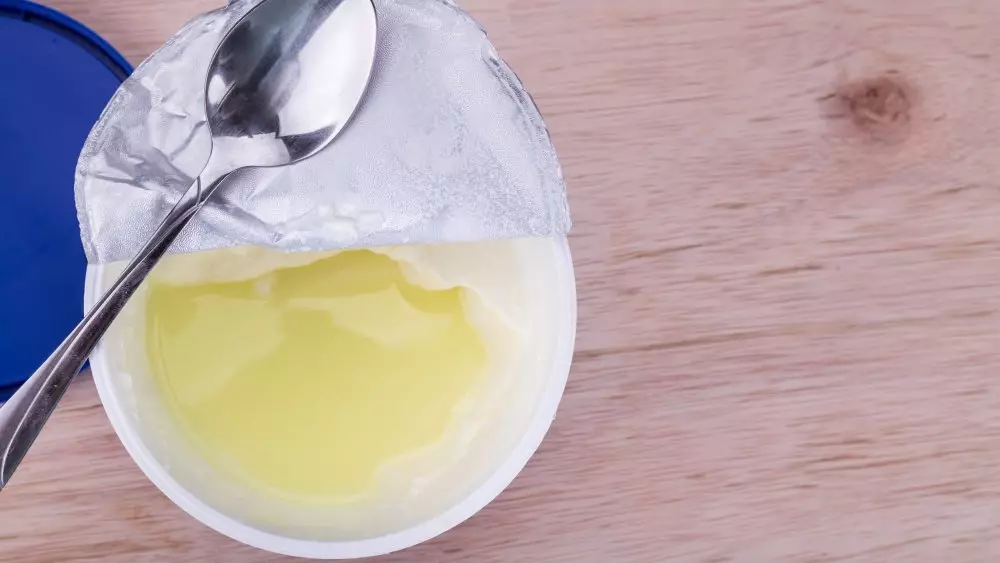 Lag med myse på toppen av yoghurt i kartong