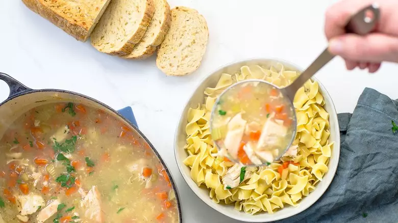 Mestolo di zuppa di tacchino sopra le tagliatelle