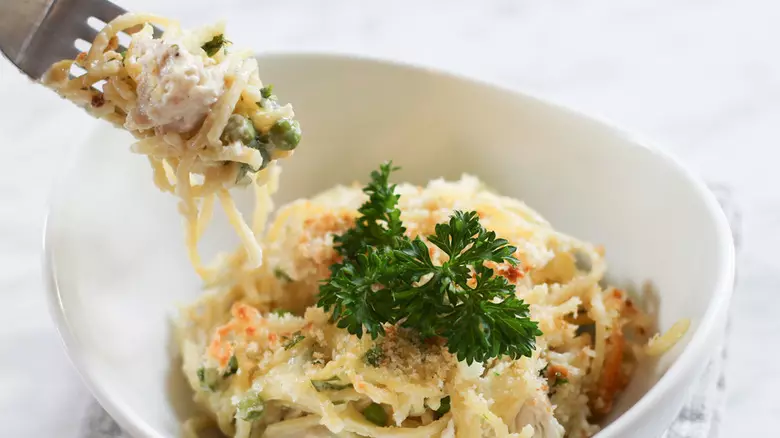 Tetrazzini de dinde facile enroulé autour d'une fourchette et dans un bol avec une garniture de persil