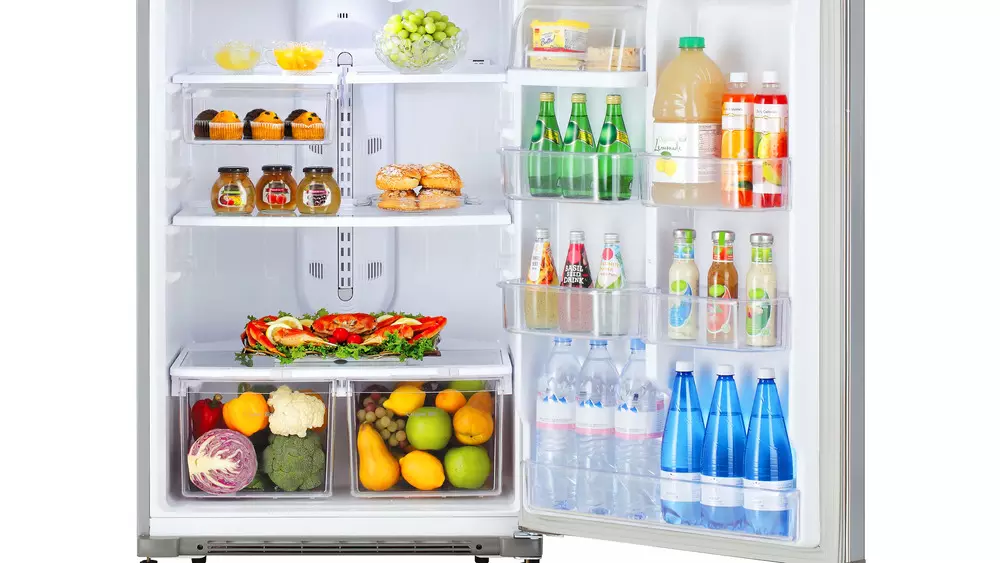 åbent køleskab med frugt, grøntsager, muffins, juice, brusende vand og ost