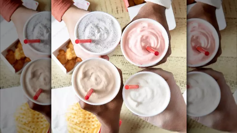 Pessoas segurando quatro milkshakes Chick-fil-A.