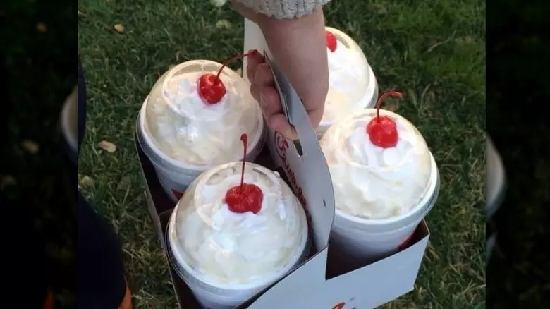 Pessoa carregando um porta-copos com quatro milkshakes Chick-fil-A