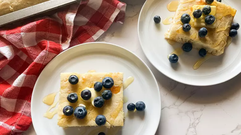 Ang hiwa ng pancake sa sheet ay makikita sa ibabaw ng blueberry, pangalawang slice at napkin