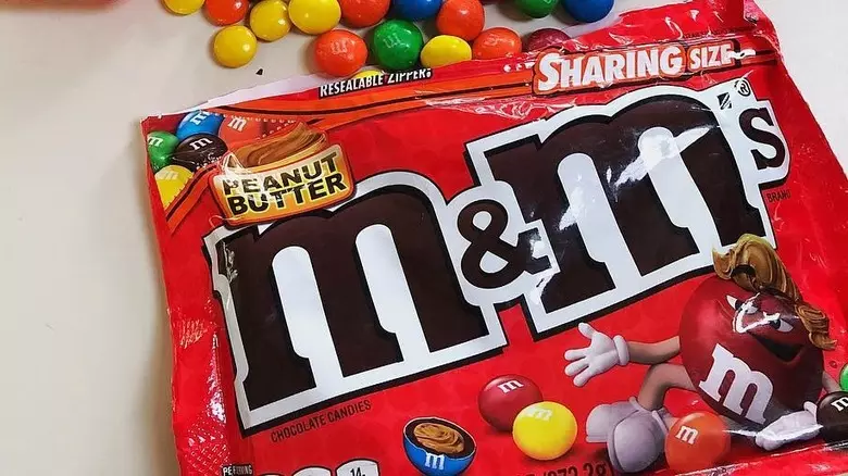 bolsa de M&M de manteiga de cacahuete con algunhas pezas no mostrador branco