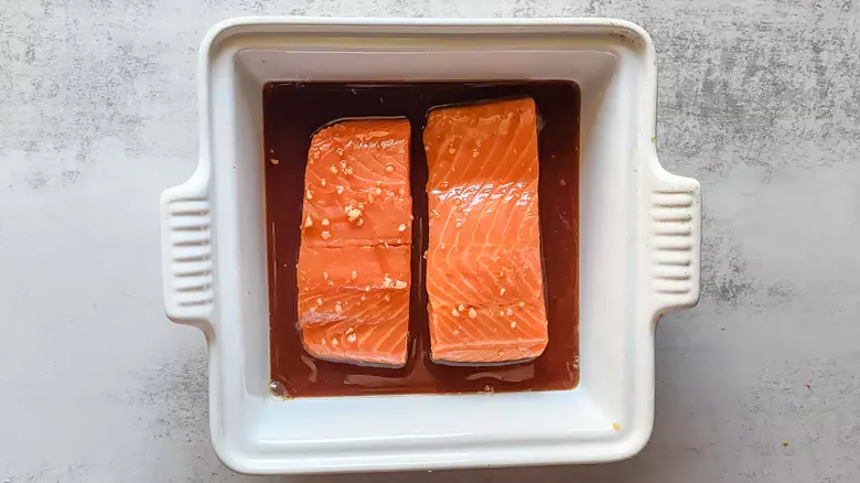Perapan fillet salmon dalam campuran soya madu