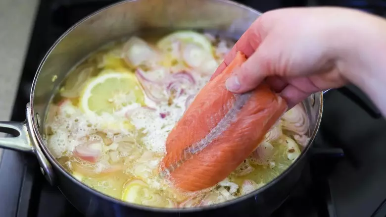 menambah filet salmon ke dalam sup