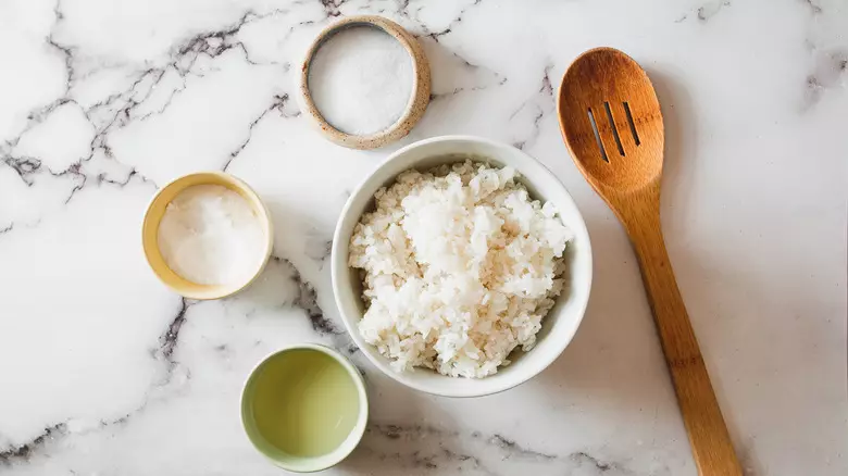 riso per sushi con ingredienti in ciotole e cucchiaio di legno