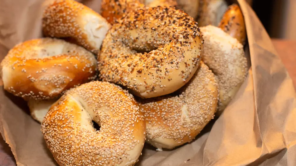 Varjetà ta 'Bagels awtentiċi assortiti stil New York biż-żerriegħa f'borża tal-karti kannella.