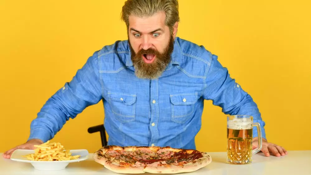 صورة تمثيلية لرجل ينظر إلى البيتزا وفمه مفتوح