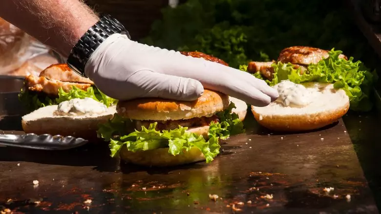 homme appuyant sur un hamburger