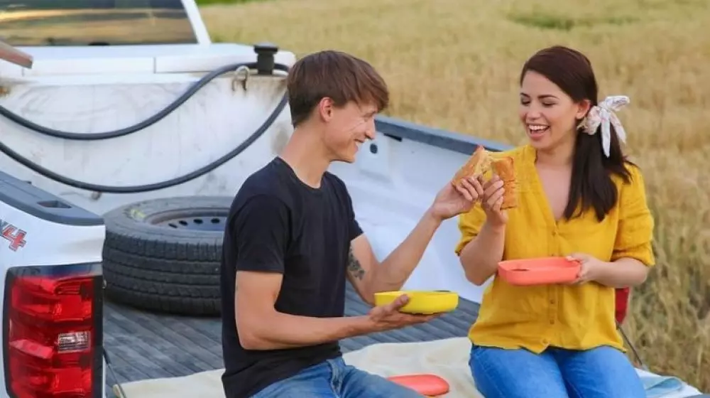 Yeh a její manžel se dělí o svačinu na korbě jejich pick-upu na farmě