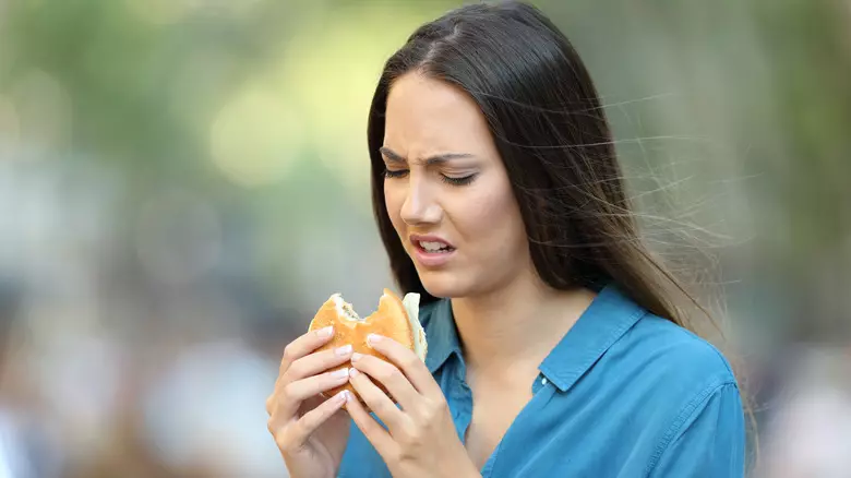 Vrouw eet slecht smakende sandwich