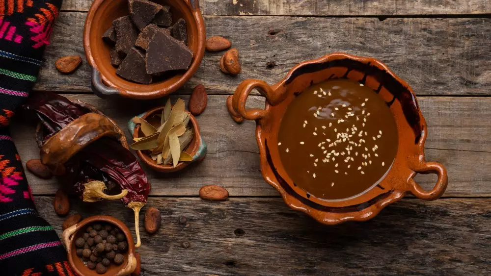 Salsa de mole en un tazón rodeado de ingredientes