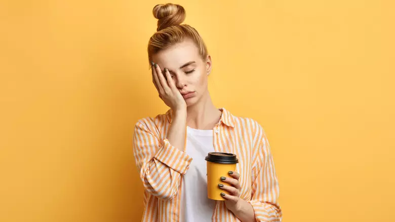 Femme fatiguée tenant une tasse de café