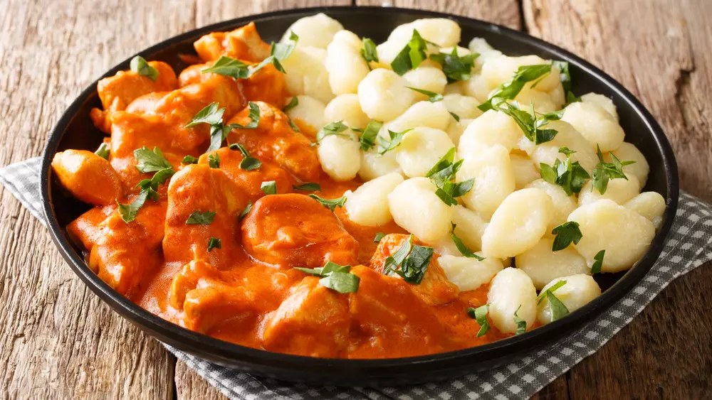 Estofado de paprikash de pollo con albóndigas en un tazón negro.