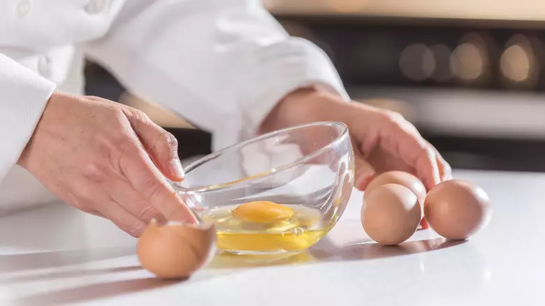 Chef-kok met kom eieren die zijn gebarsten