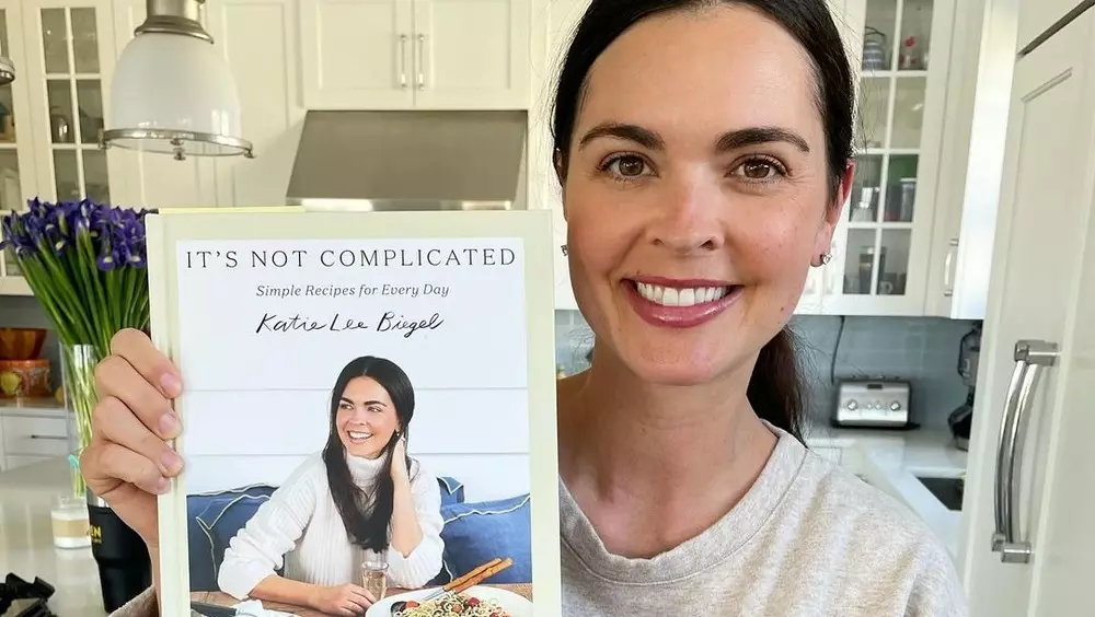 Katie Lee Biegel hält ihr neues Kochbuch in der Hand