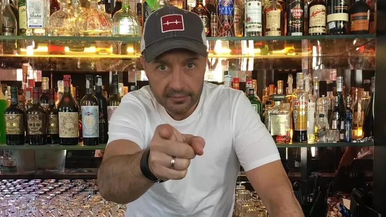 De Joe Bastianich steet an enger Bar viru ville Fläschen