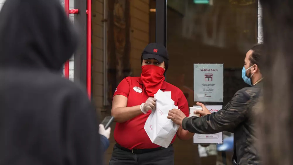 Een medewerker van Chick-fil-A die een masker draagt.