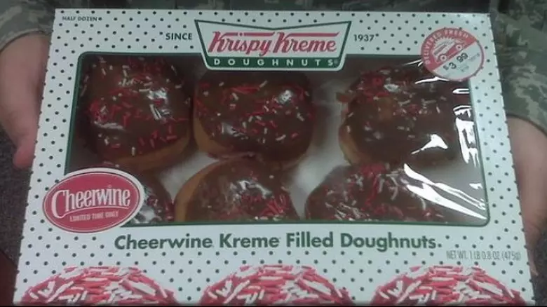 ხელში უჭირავს Cheerwine Krispy Kreme დონატების ყუთი