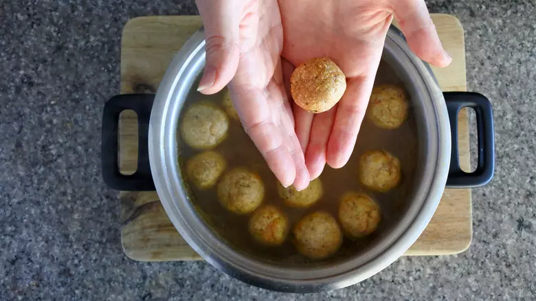 Une paire de mains faisant de la soupe aux boules de mazzo