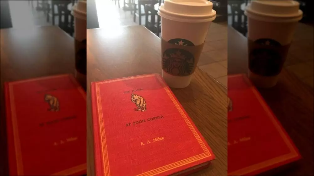 Starbucks bardağı ve Pooh Köşesindeki Ev kitabı