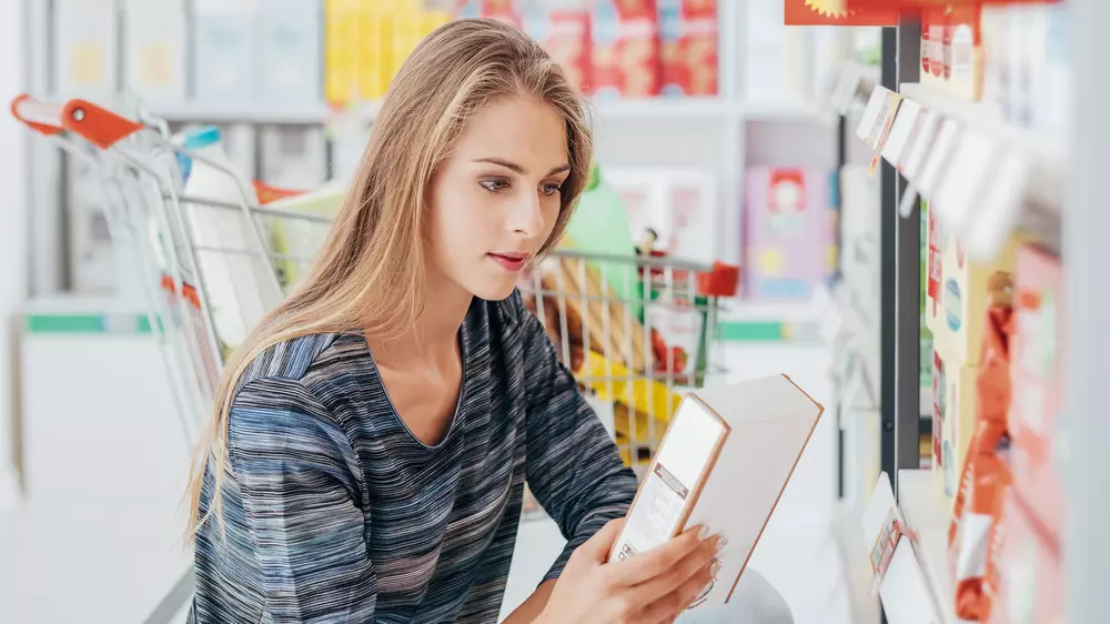 wanita membaca label makanan kemasan