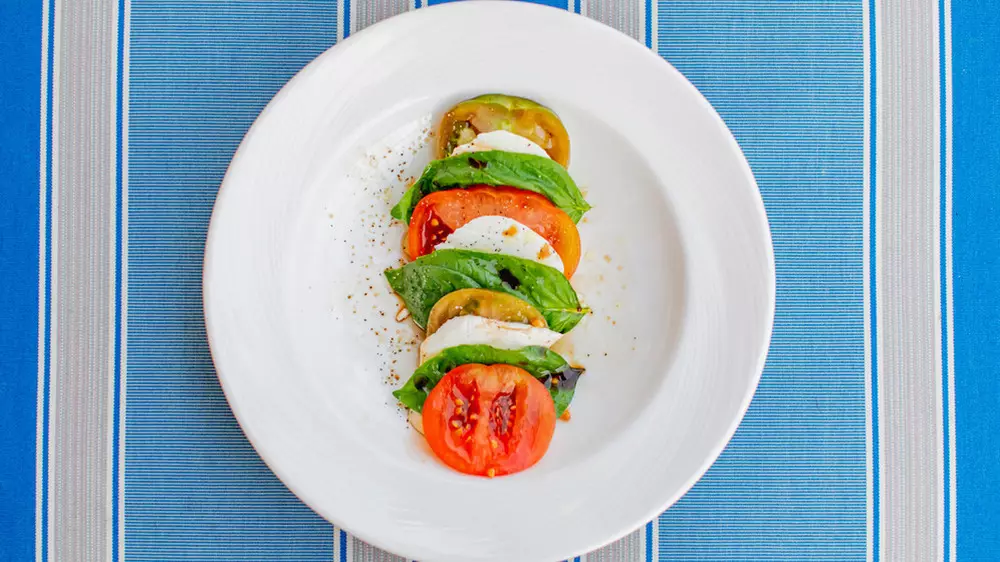 Salad Caprese na basil ọhụrụ na tomato na efere