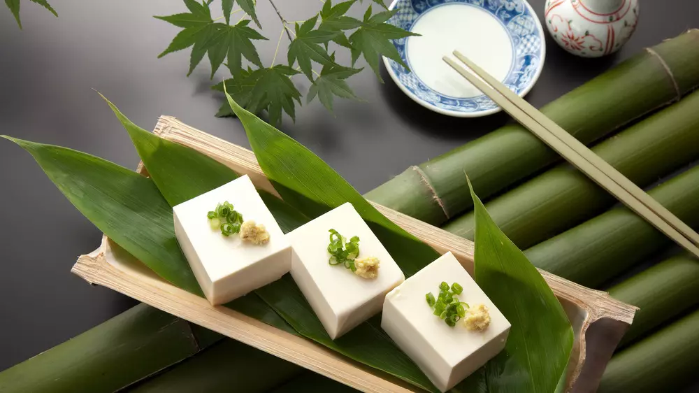 blocs de tofu sur feuilles avec des baguettes